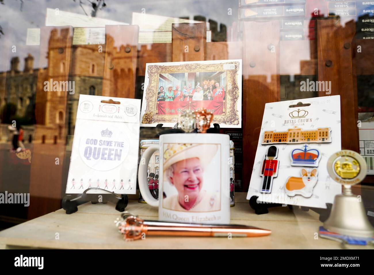 Windsor Castle is reflected on a window of a shop which displays ...