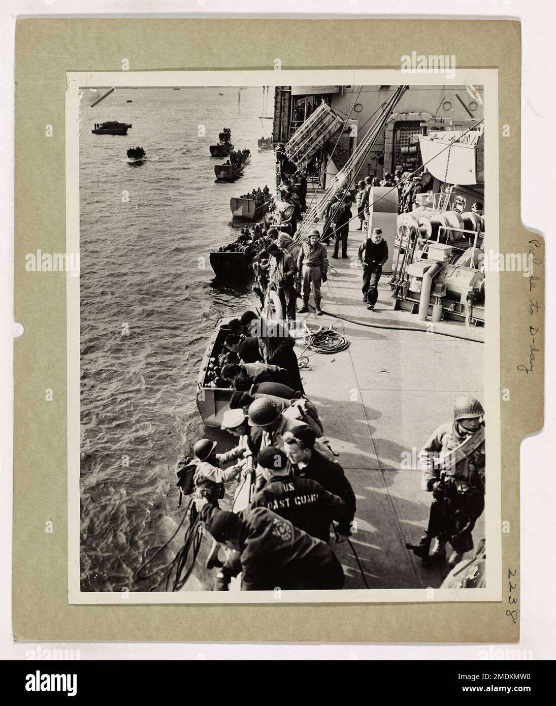 Helmeted U.S. troops board a Coast Guard-manned assault transport off ...