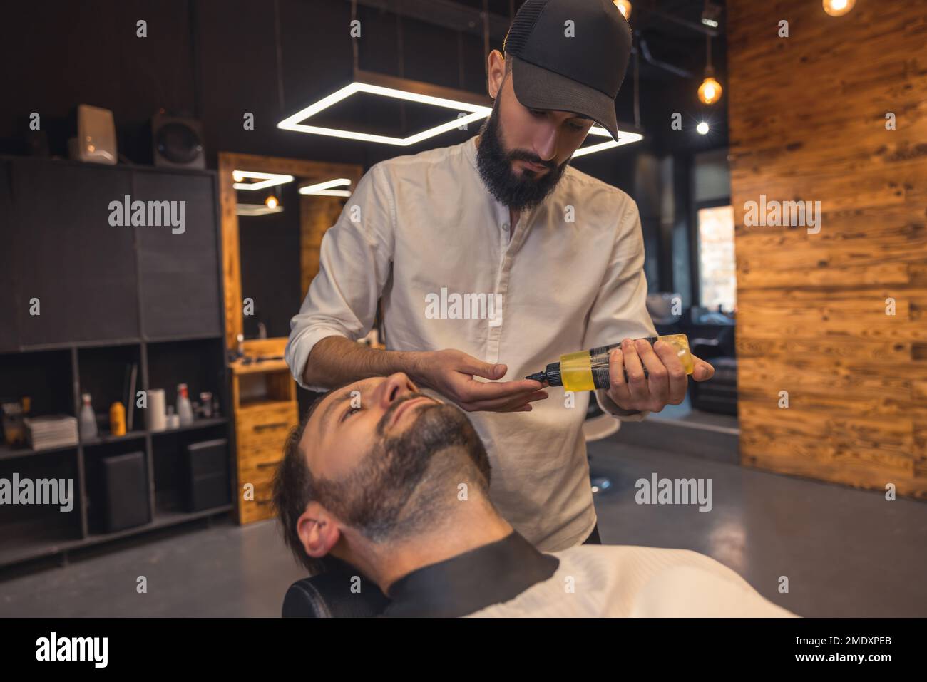 Barber applying moisturizer on the clients face Stock Photo - Alamy