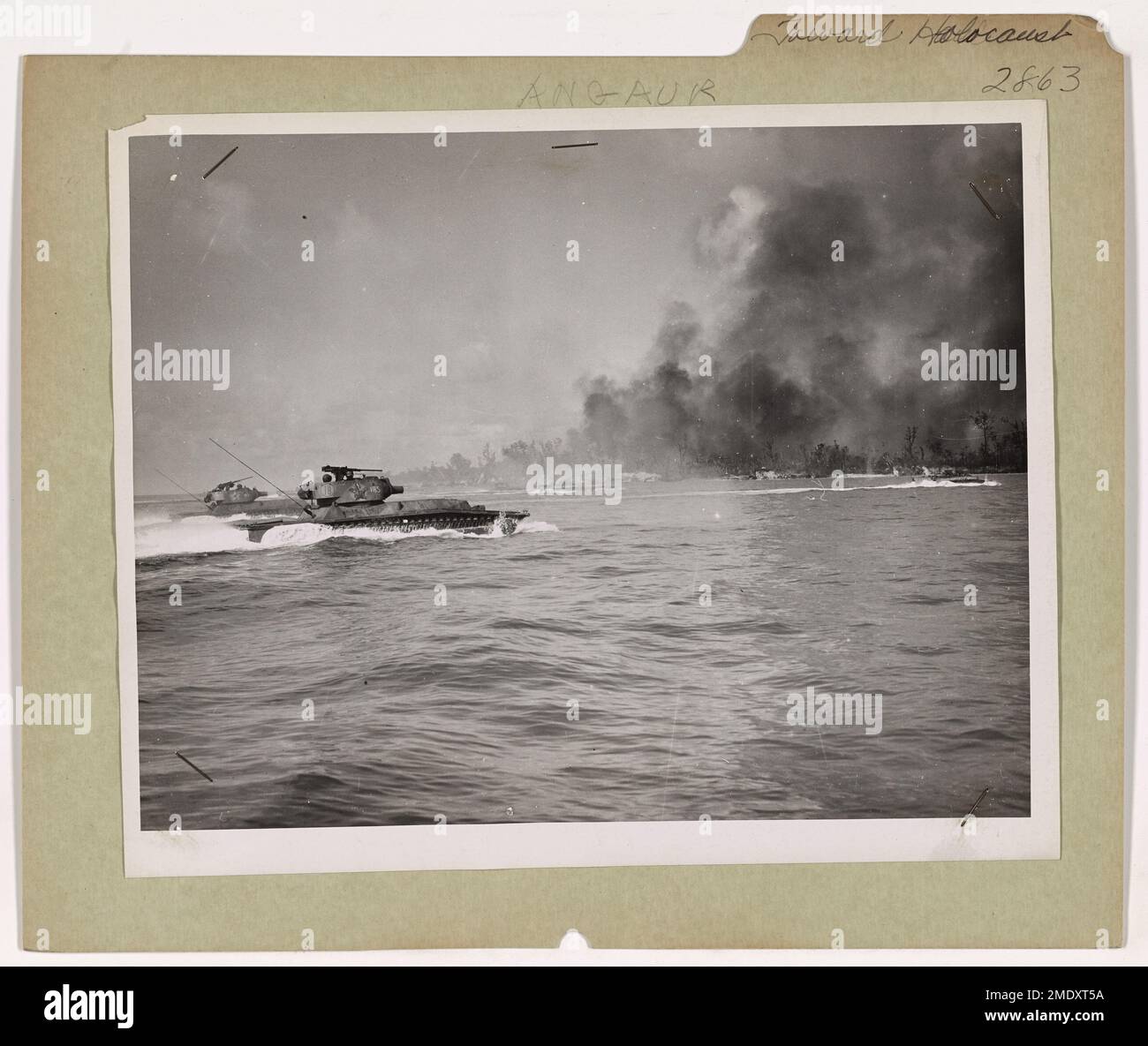 Amphibious tanks, loaded with guns, churn toward the flaming beaches of ...