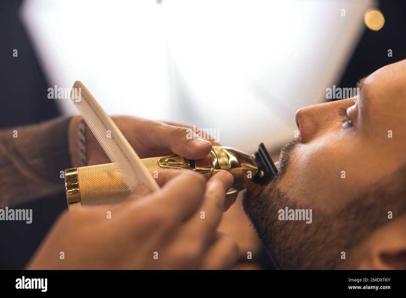 Barber in the salon working on the clients beard Stock Photo - Alamy