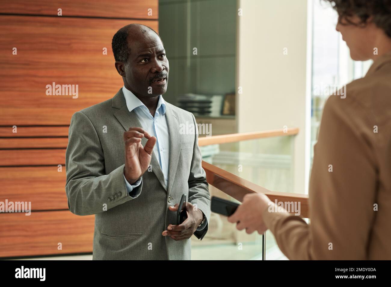 Confident employer in formalwear giving instructions or explaining ...