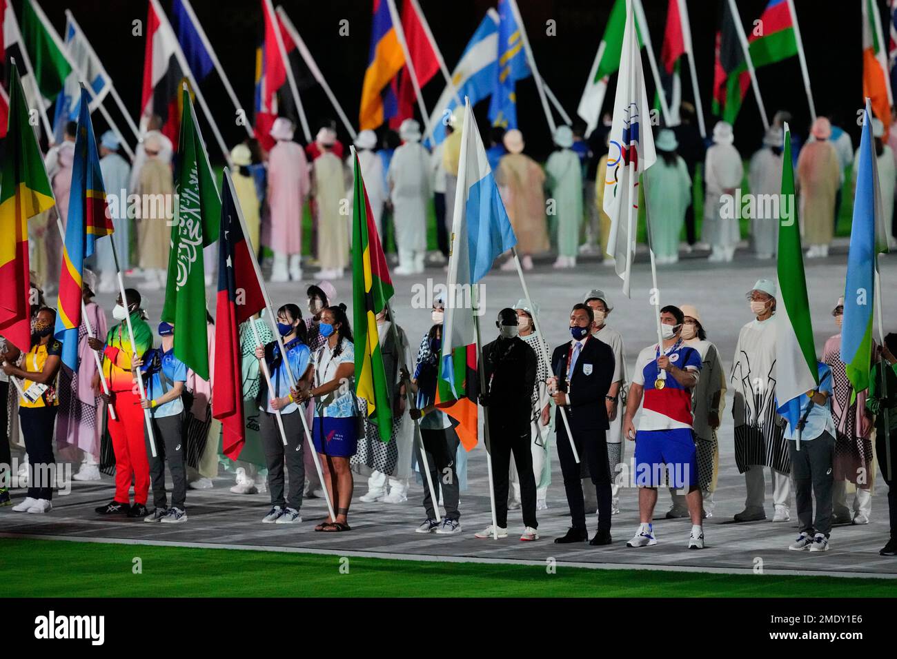 Athletes and volunteers carry flags during the closing ceremony in the ...