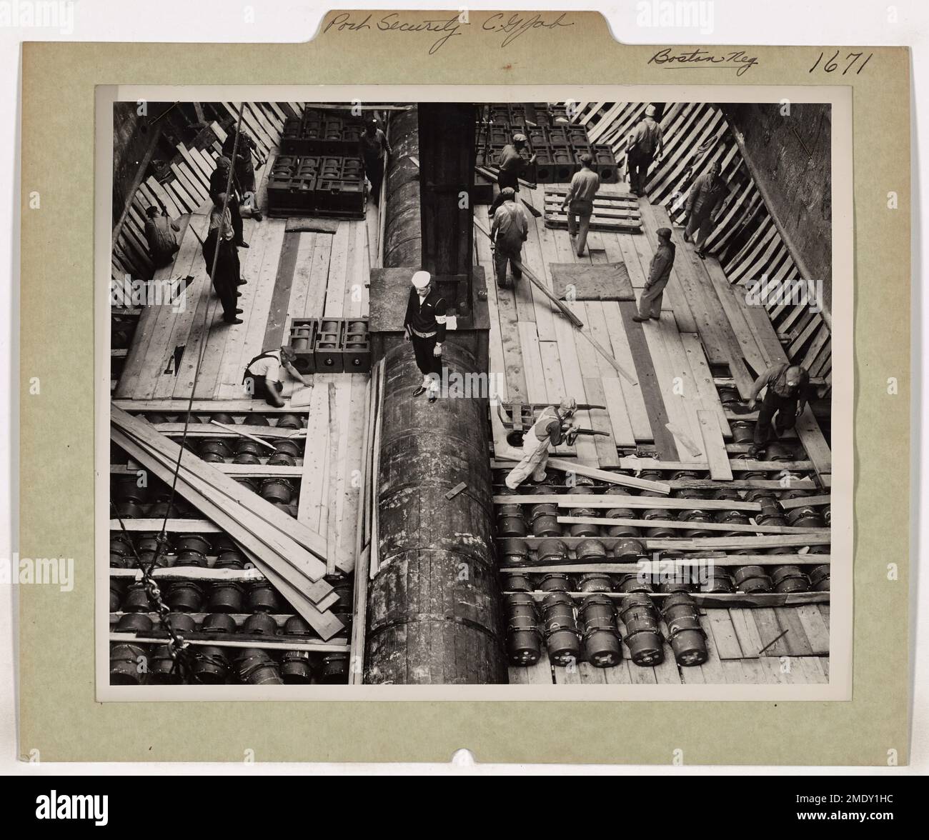 Ship workmen aboard a U.S. Coast Guard vessel secure the flooring over ...