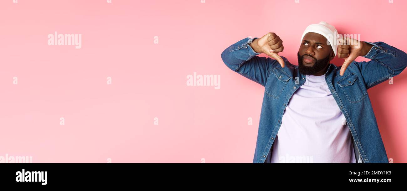 Disappointed Black man staring at upper left corner annoyed, showing ...