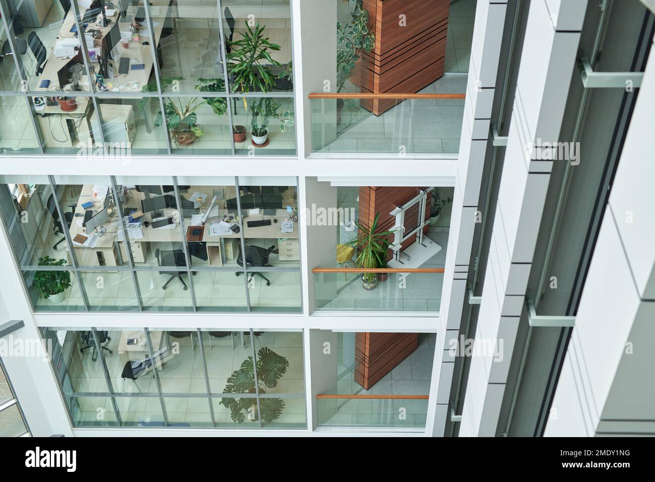 Part of modern multi-storey building with rows of desks, armchairs and ...