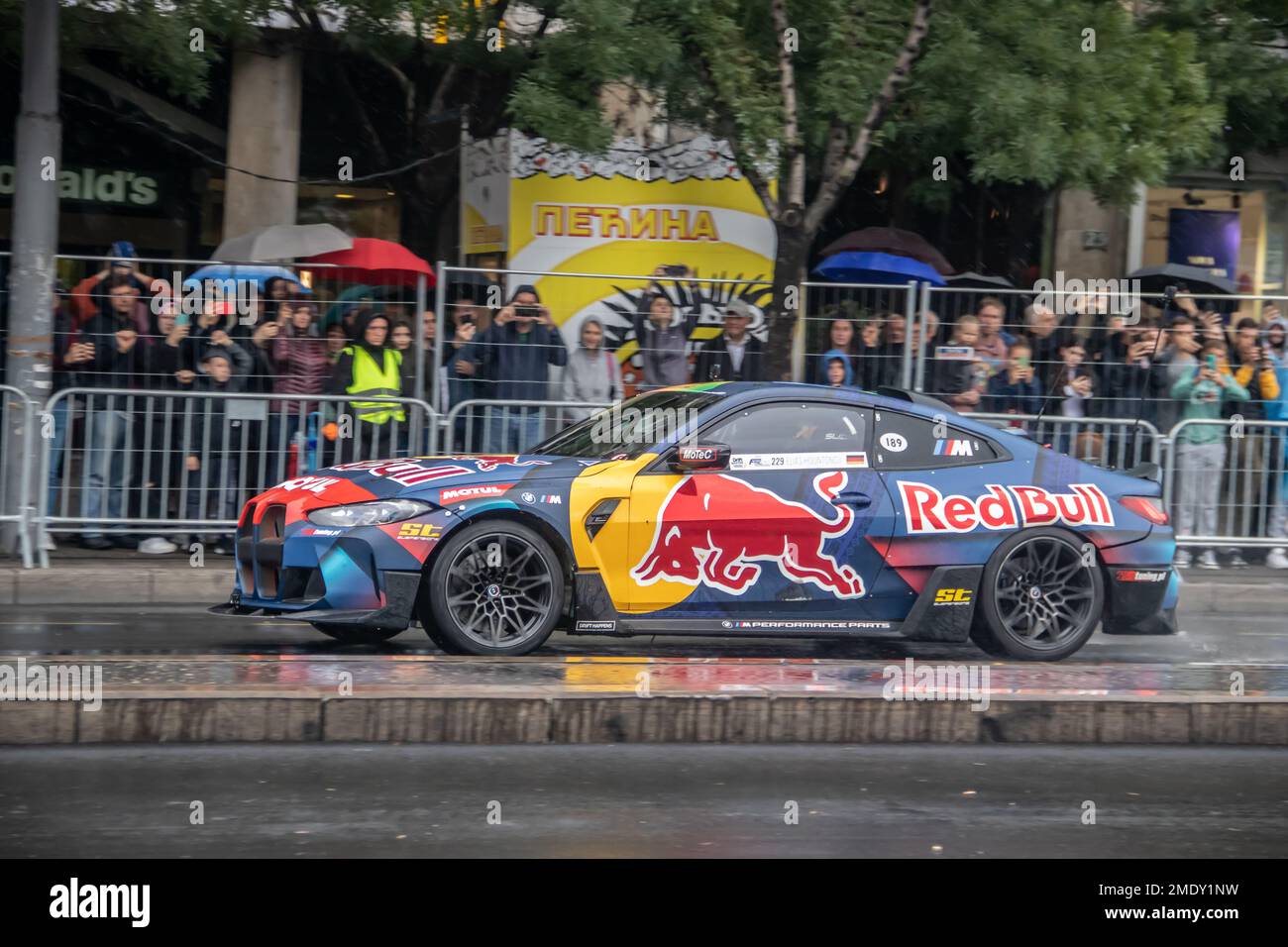 Racing red-bull sport vehicle on city streets, driven by Elias ...