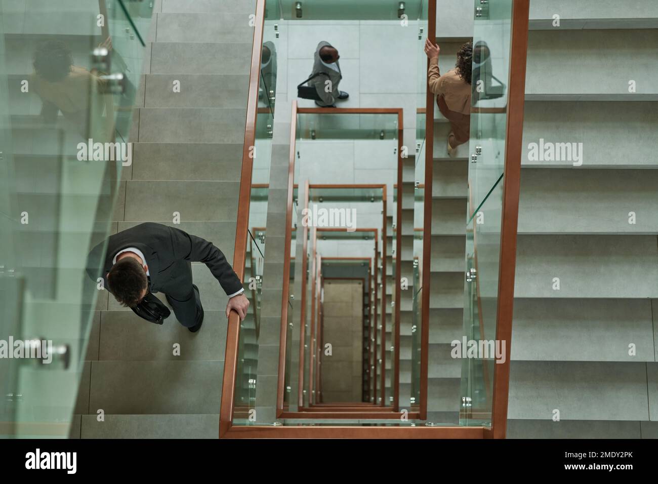 Above shot of three business people in formalwear walking upstairs and ...