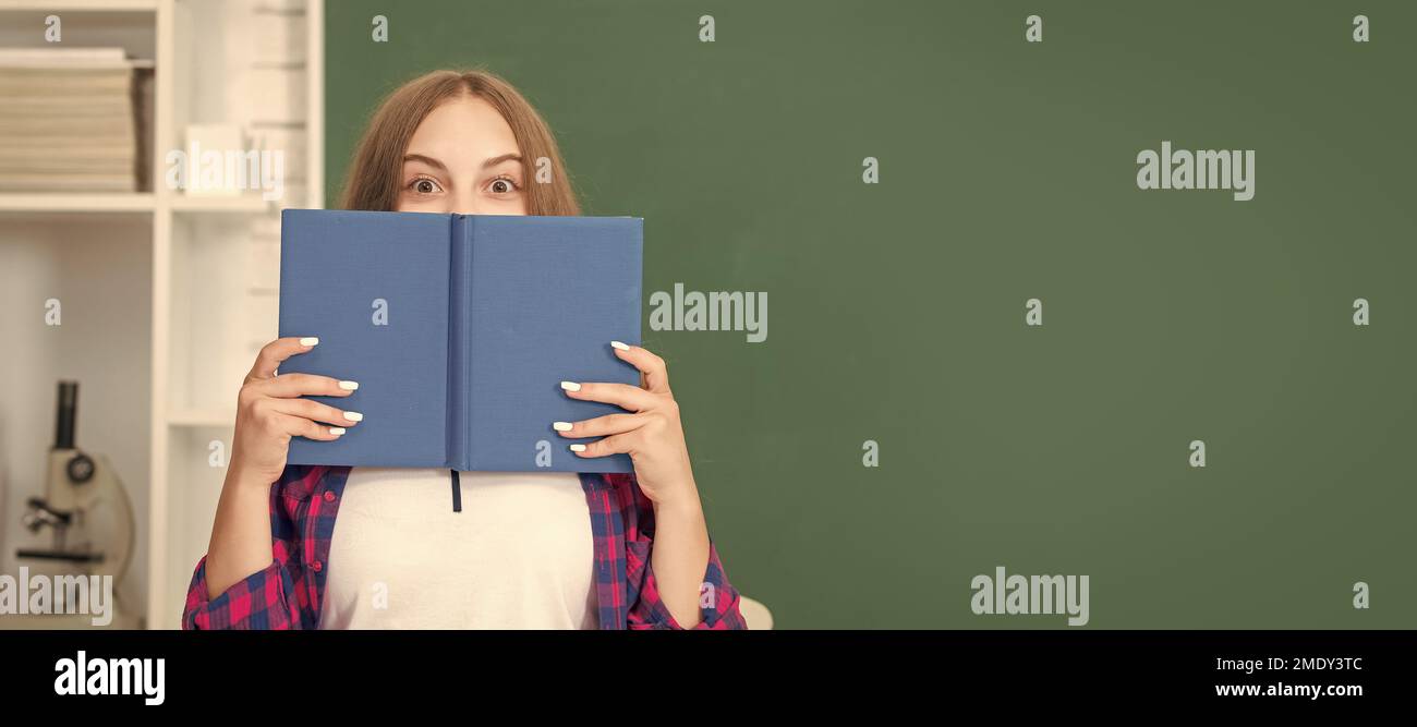 teen girl in high school behind workbook at blackboard. Portrait of ...