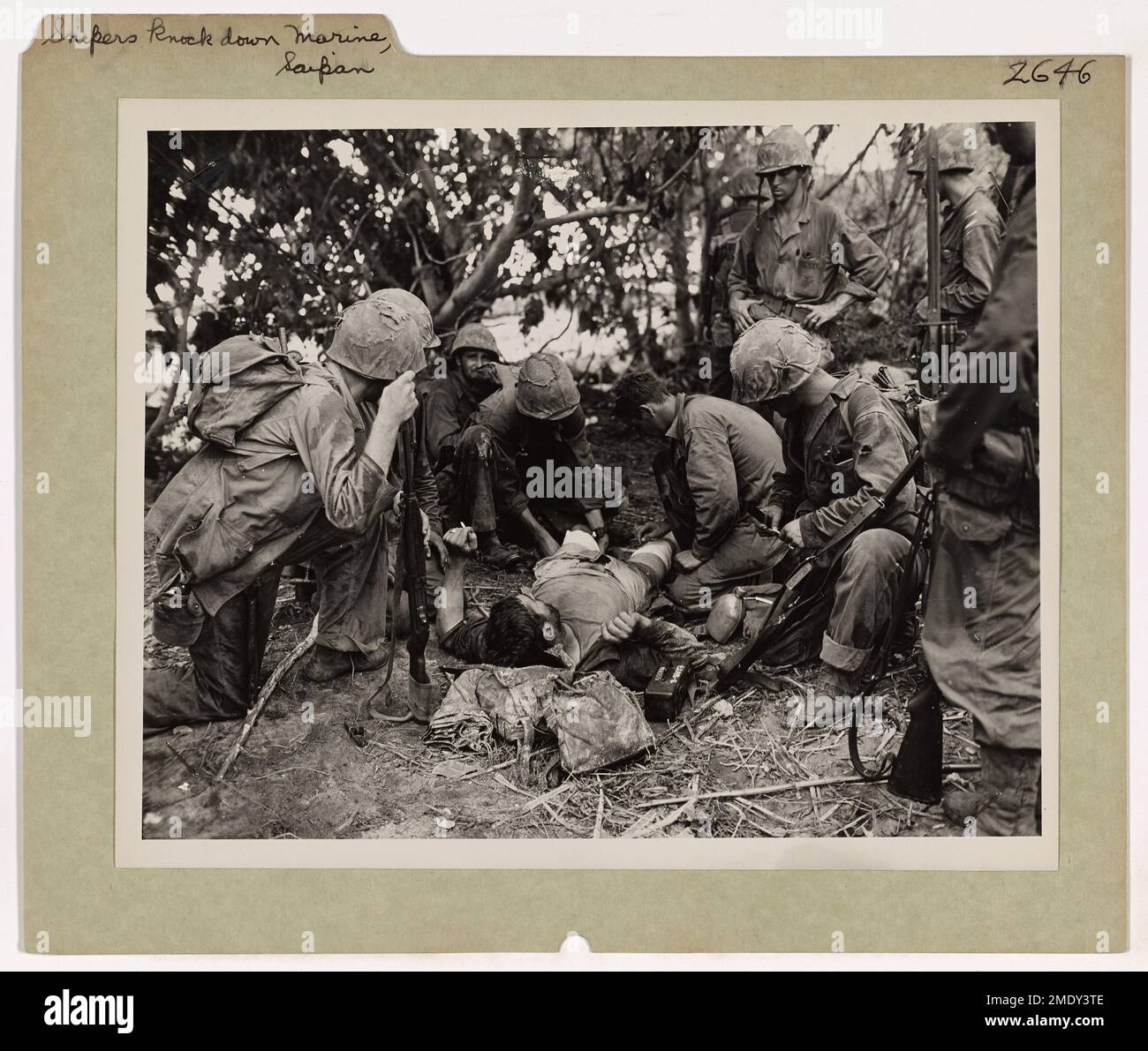 A photograph shows American Marines providing first aid to a wounded ...