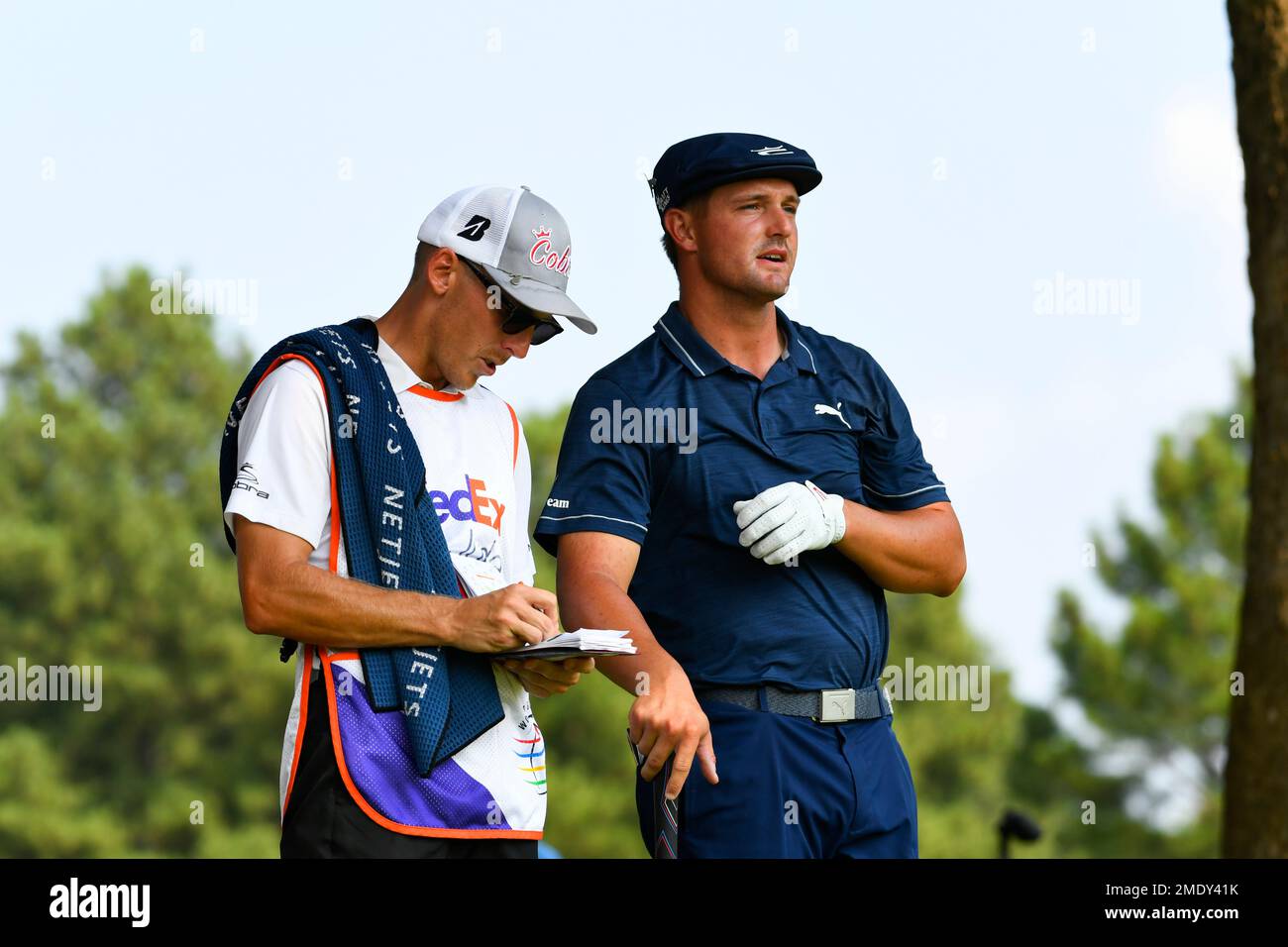 Bryson Dechambeau stands with caddie Brian Zeigler, left, as he waits ...
