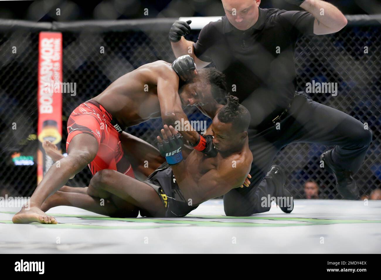 Marvel Kape, left, punches Ode Osbourne, middle, after taking him down ...