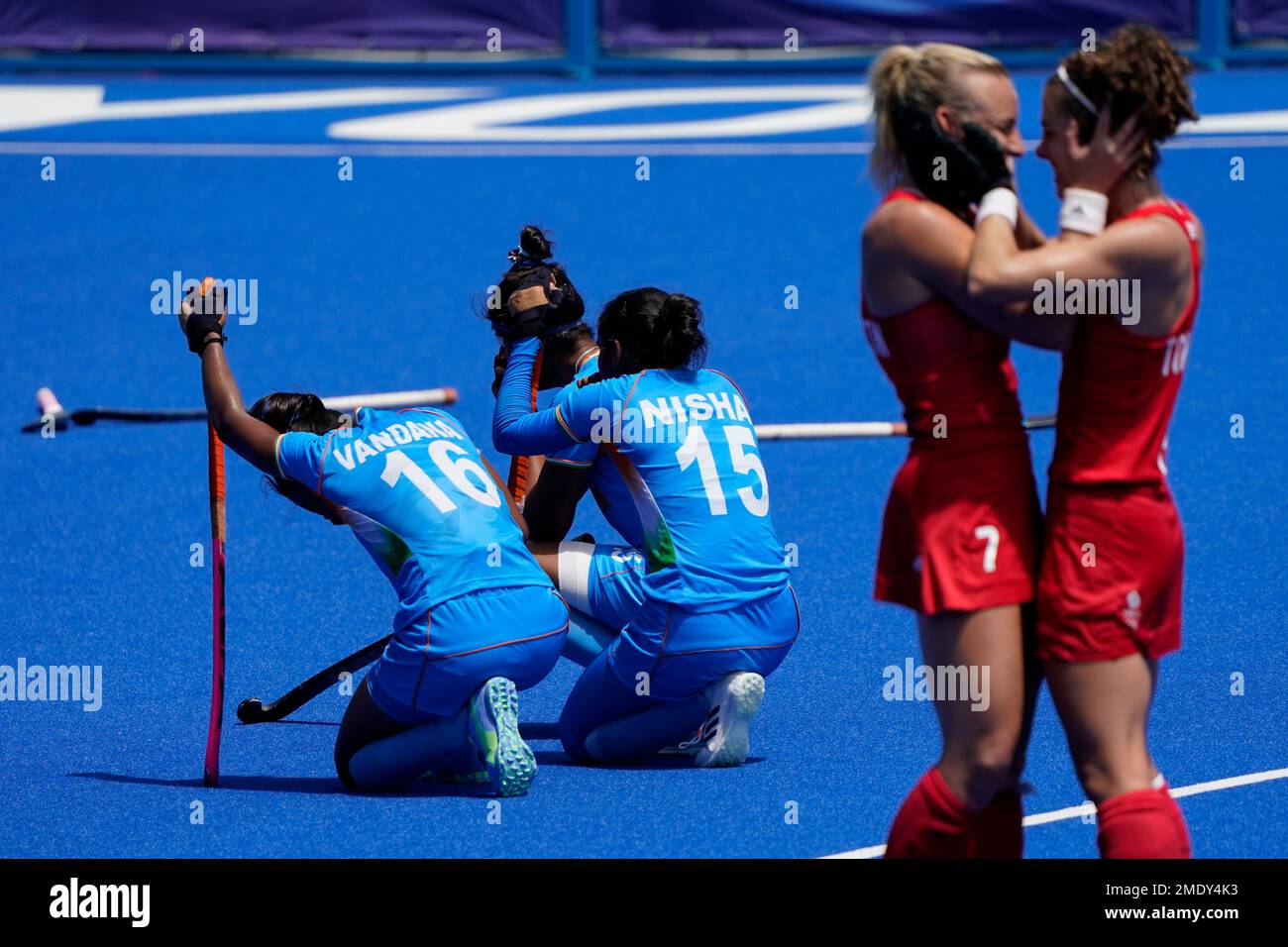 India's Vandana Katariya (16) and India's Nisha (15) kneel on the field ...