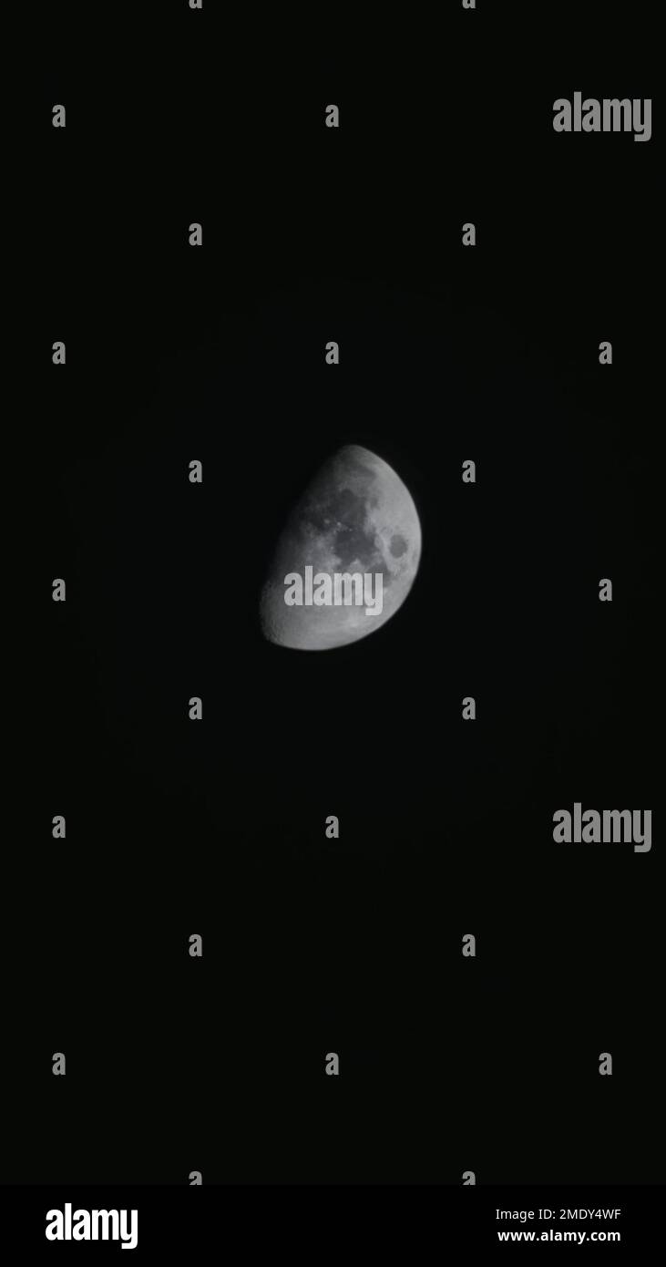 A vertical closeup of the half moon in a dark night sky Stock Photo - Alamy