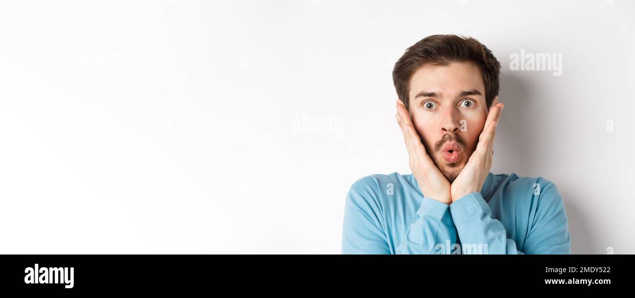 Close-up of impressed man checking out special offer, saying wow and ...