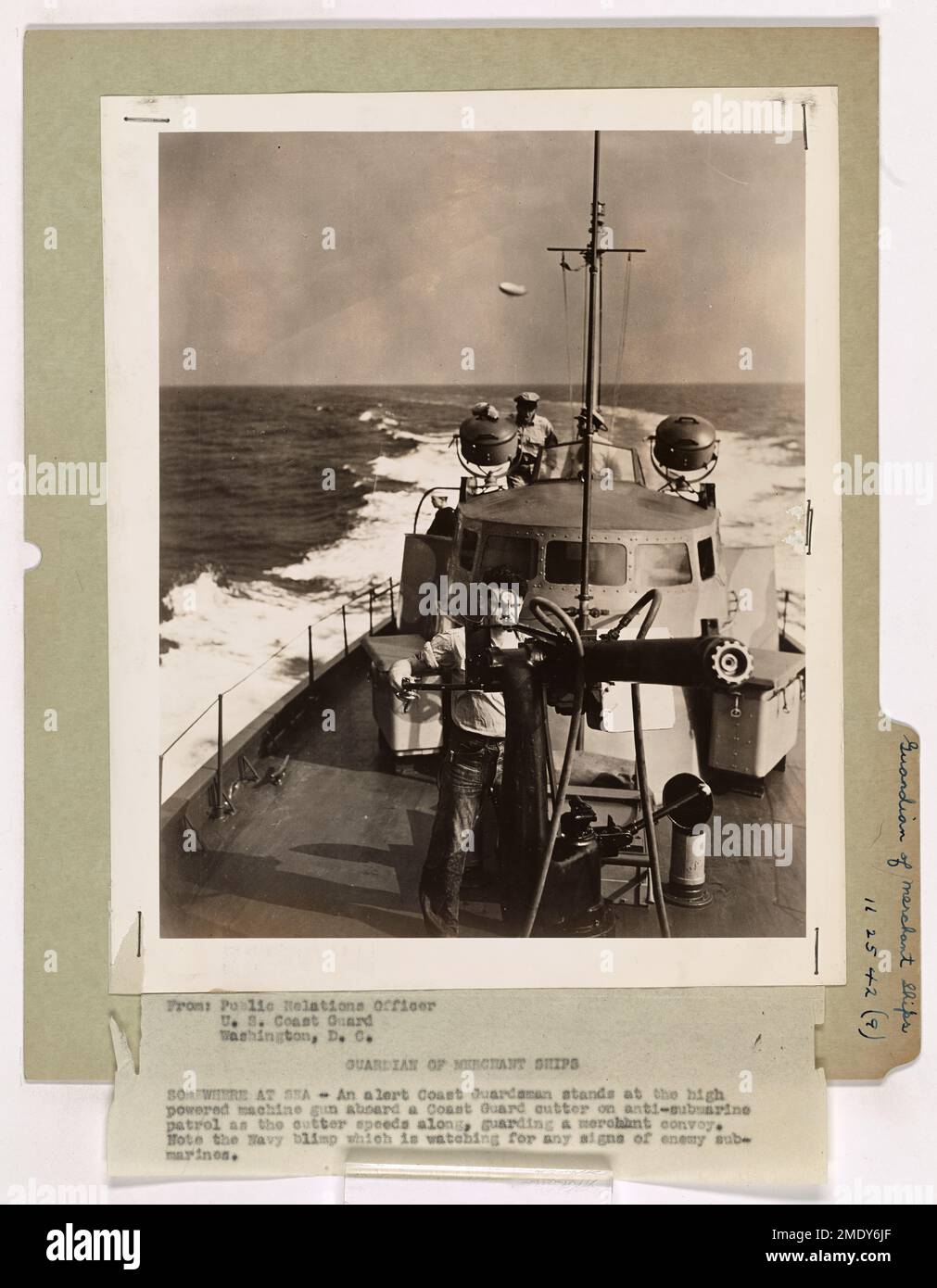 A Coast Guardsman stands alert at the high-powered machine gun aboard a ...