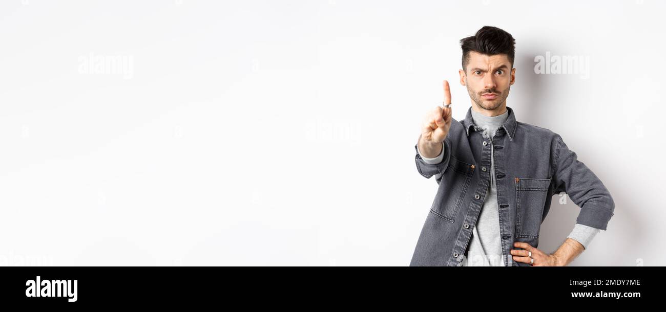 Stop right here. Serious man scolding, shaking finger and frowning ...