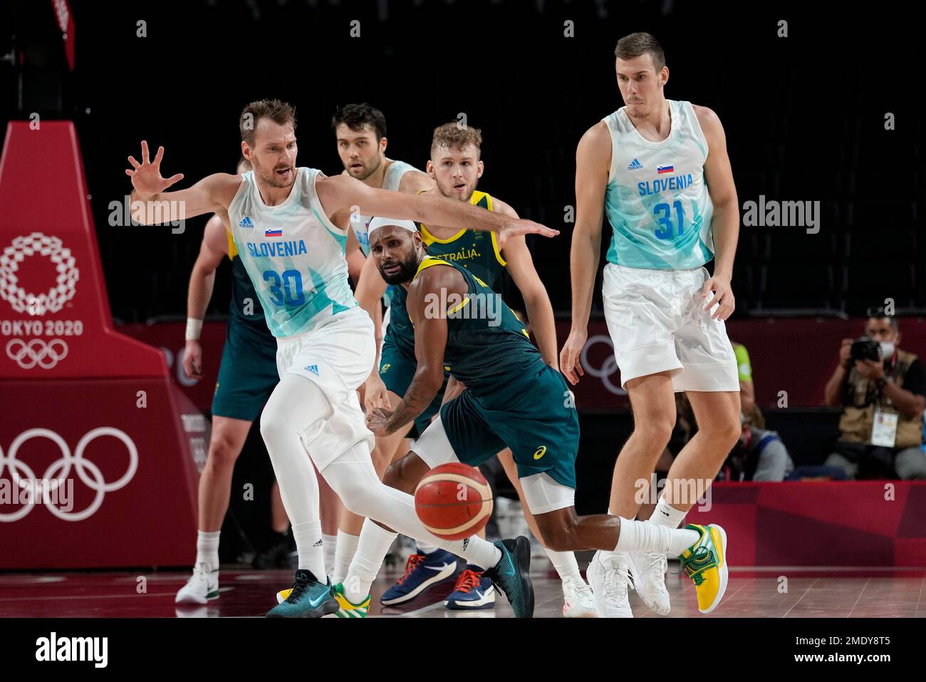 Australia's Patty Mills, center, strips the ball from Slovenia's Zoran ...