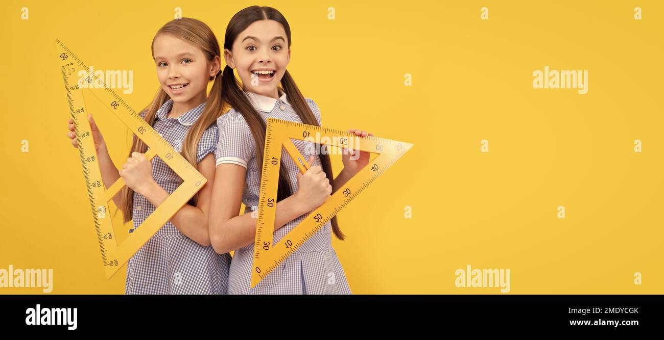 School girls friends. Happy teen girls hold triangular rulers. School ...