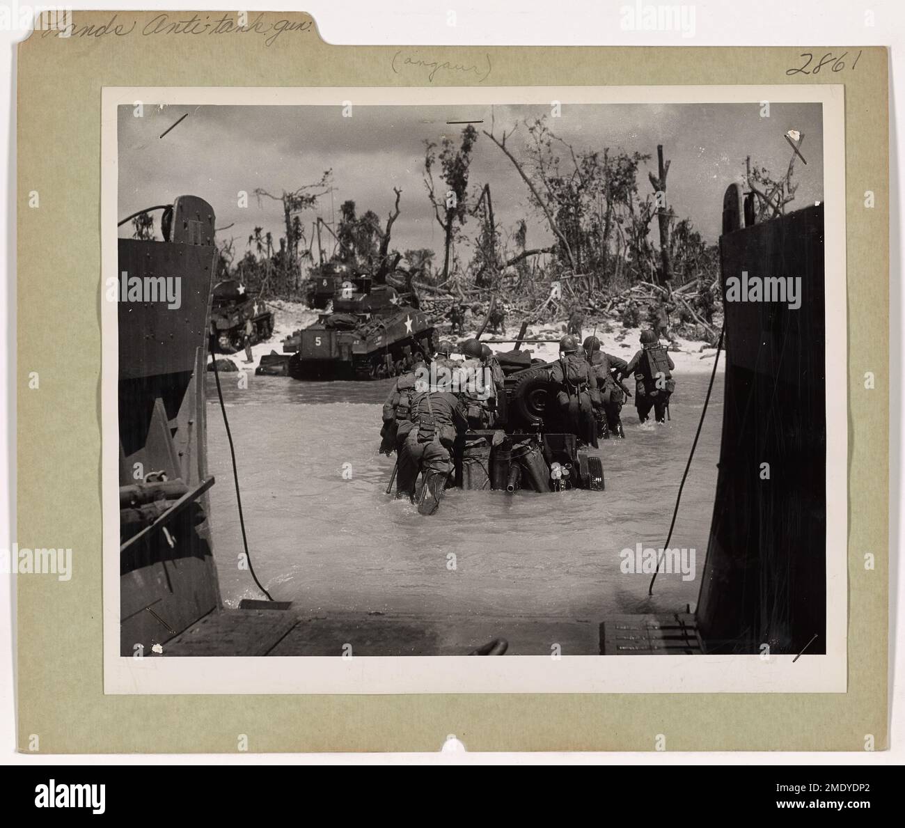A Coast Guard-manned landing barge transports an anti-tank gun to the ...