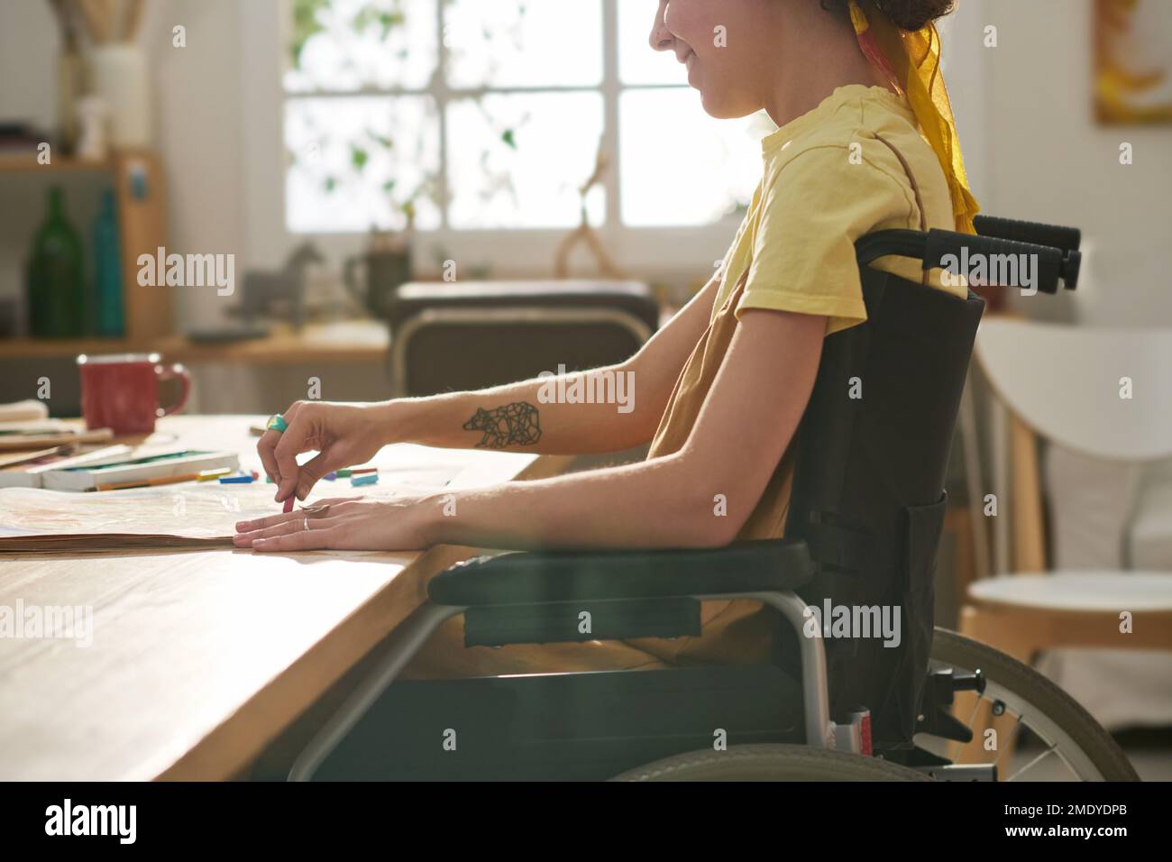 close-up-of-happy-young-woman-with-disability-sitting-in-wheelchair-by