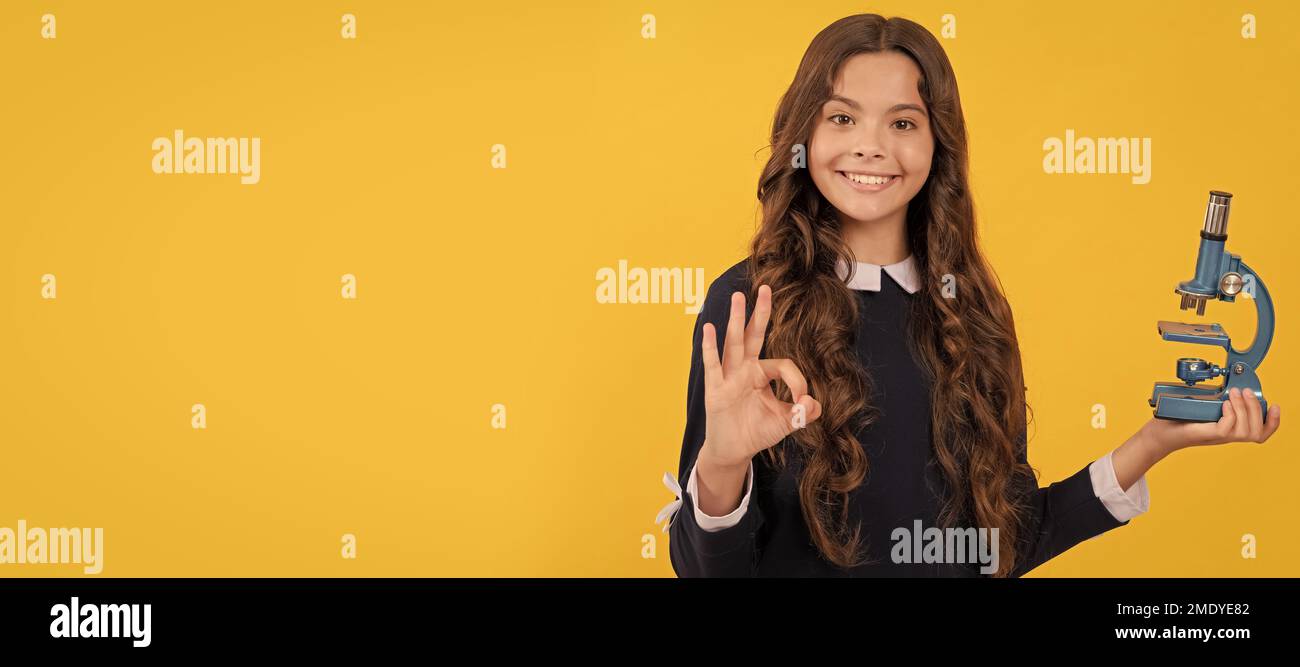 science and childhood. teen girl presenting microscope. Portrait of ...