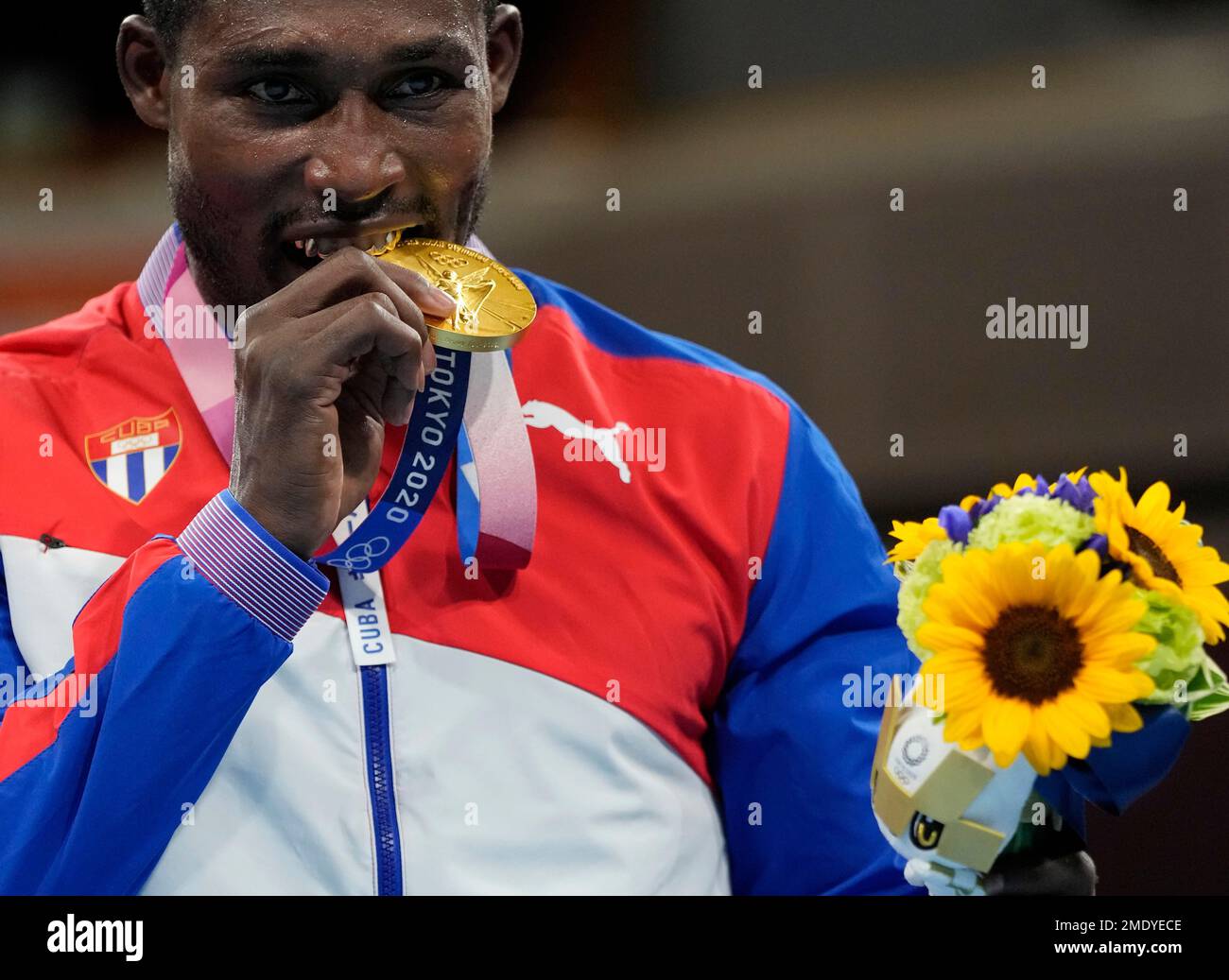 Gold medallist Cuba's Julio la Cruz bites his medal as he poses for ...