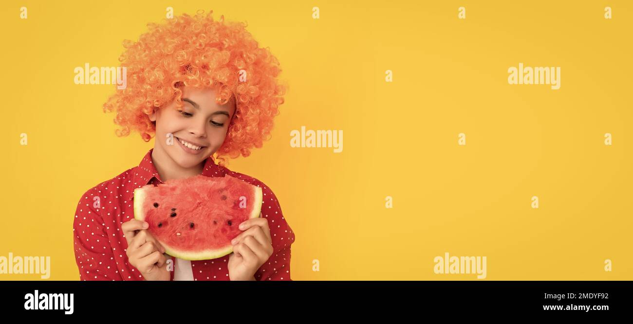 smiling teen girl in fancy orange hair wig hold fresh ripe watermelon ...