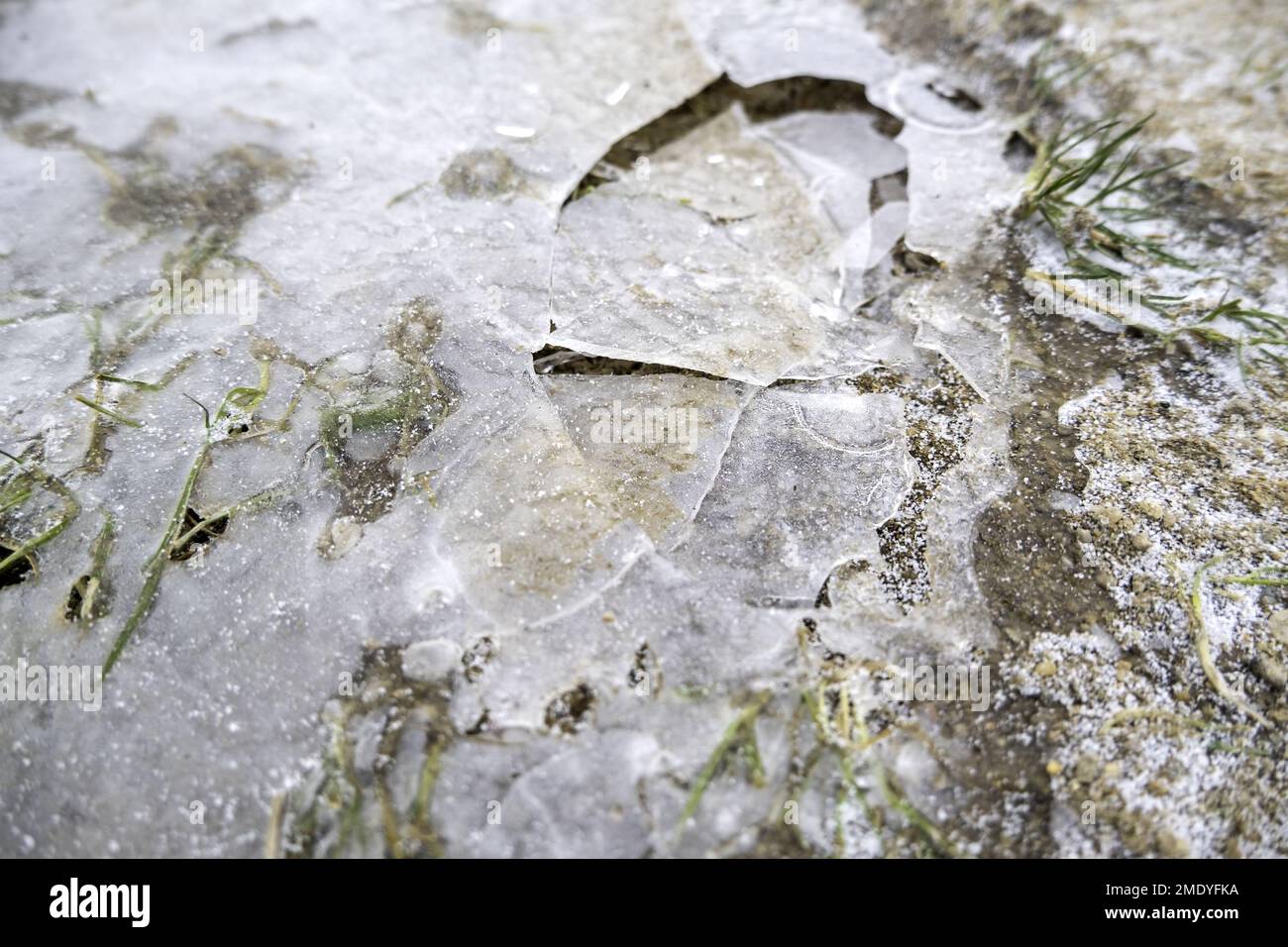 Detail of cold winter day, frost and freezing of water in the street ...