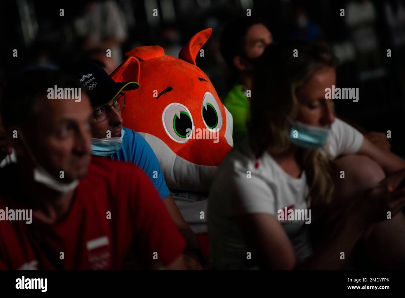 A mascot for the Slovenian Olympic team sits in the audience as ...