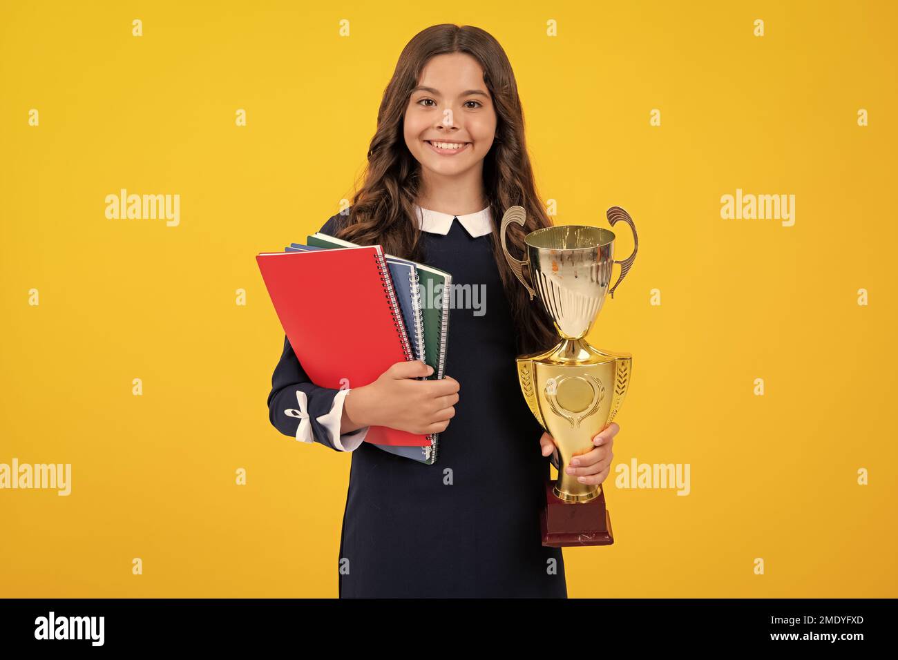 Teenager school girl with award winner trophy. Child hold books with ...