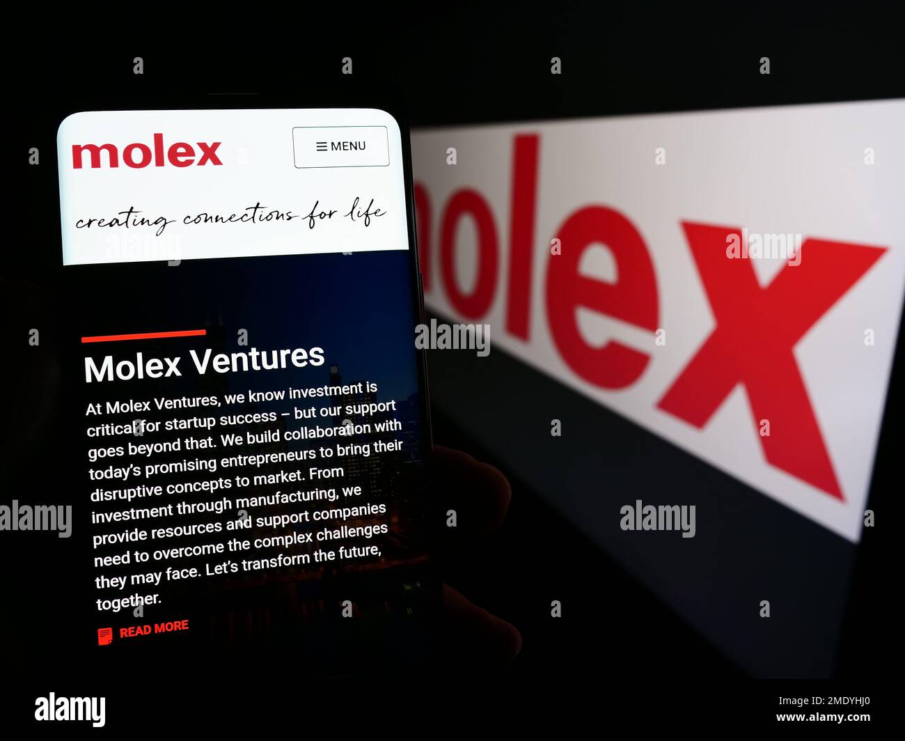 Person holding mobile phone with webpage of US connector manufacturing ...