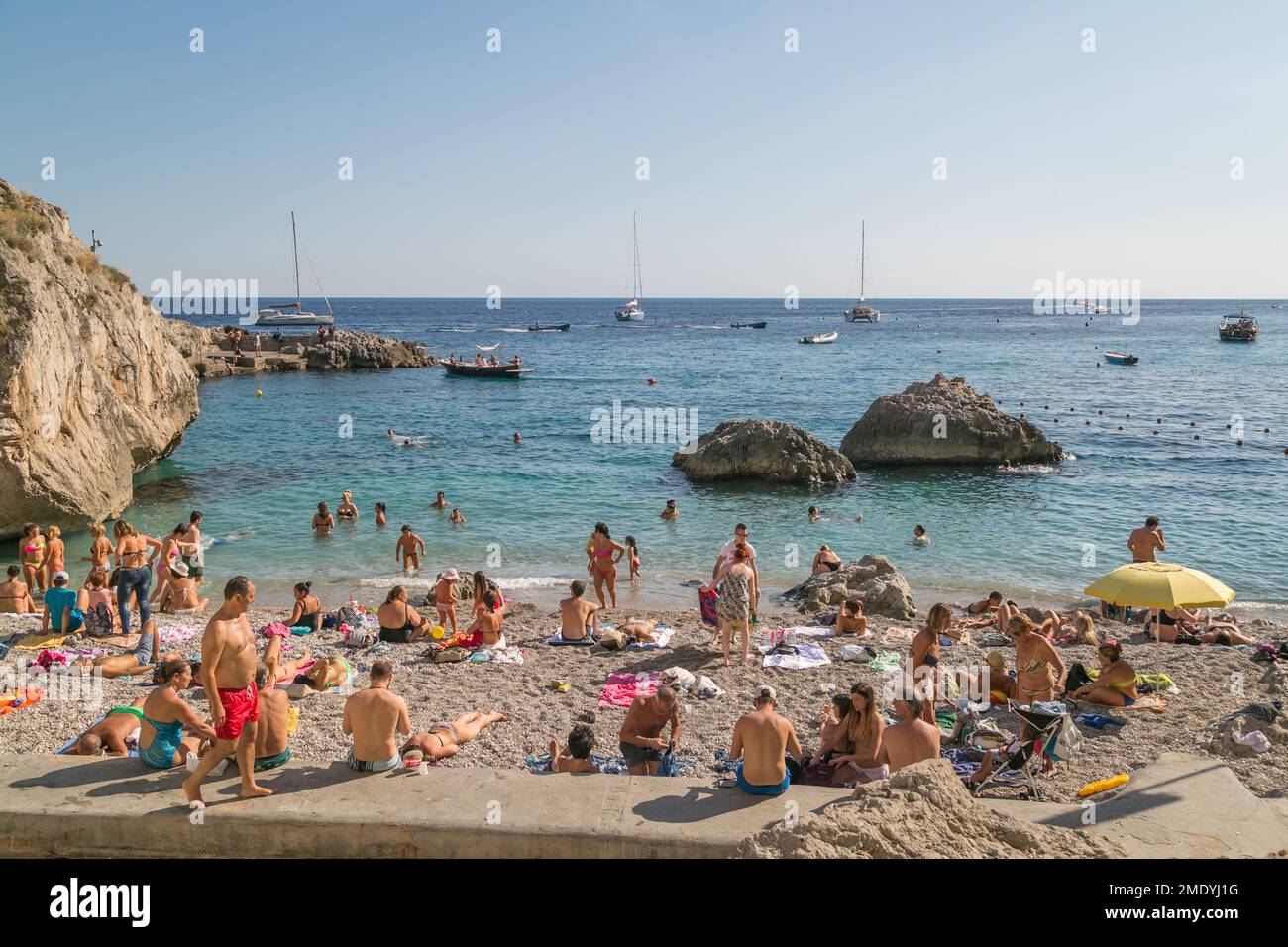 People swimming and sunbathing in the summer on the beach of Capri, Bay ...