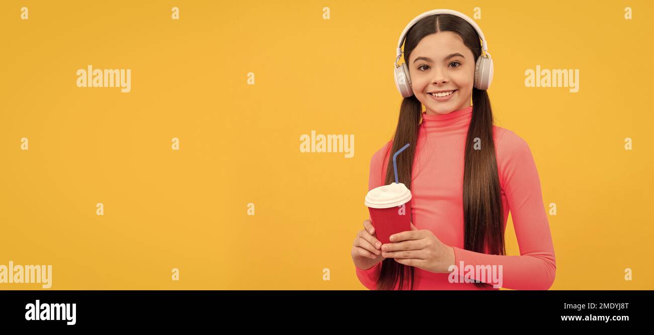 happy kid listen music in headphones with paper cup on yellow ...