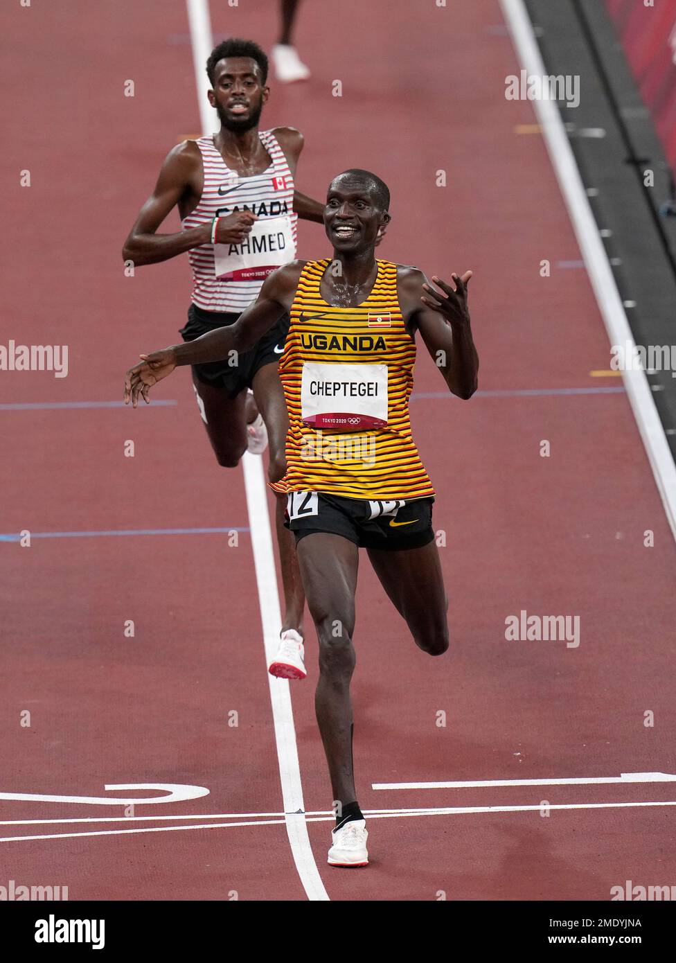 Joshua Cheptegei, of Uganda, leads Mohammed Ahmed, of Canada to win the ...