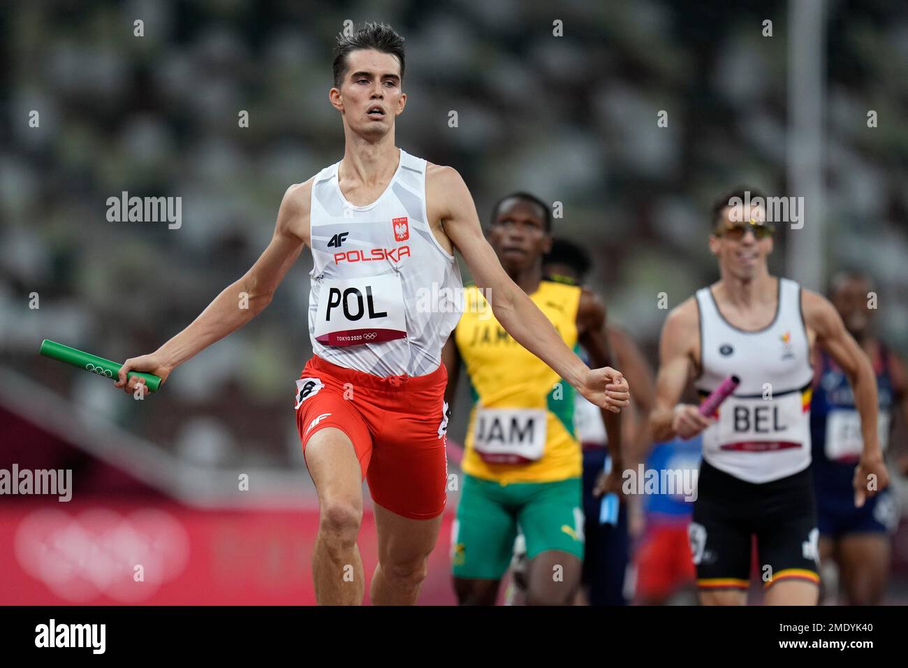 A runner from team Poland crosses the finish line in their heat of the ...