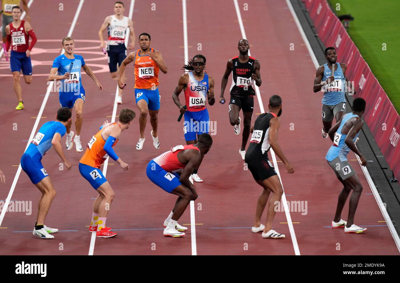 Runners prepare to make a baton handover in a semifinal of the men's 4 ...