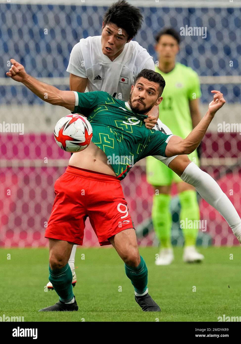 Japan's Takehiro Tomiyasu jumps behind Mexico's Henry Martin in the men ...