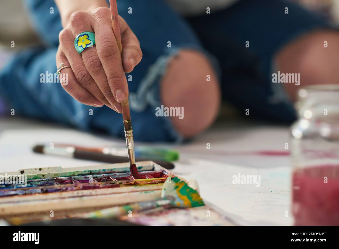 Focus on hand of young creative woman with bijou ring putting ...