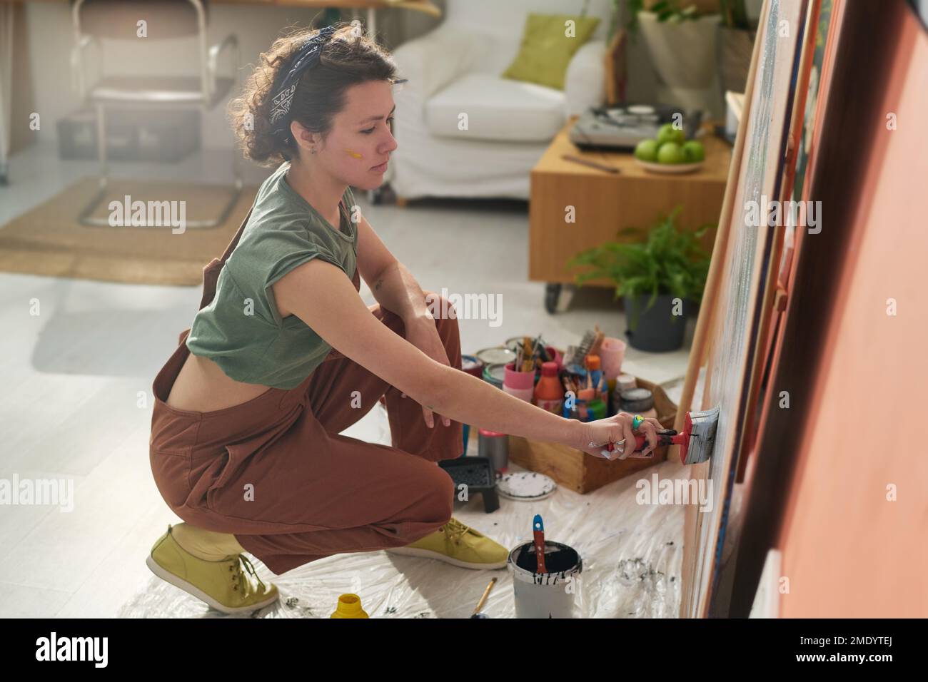 Young serious woman concentrating on creation of new artwork while ...
