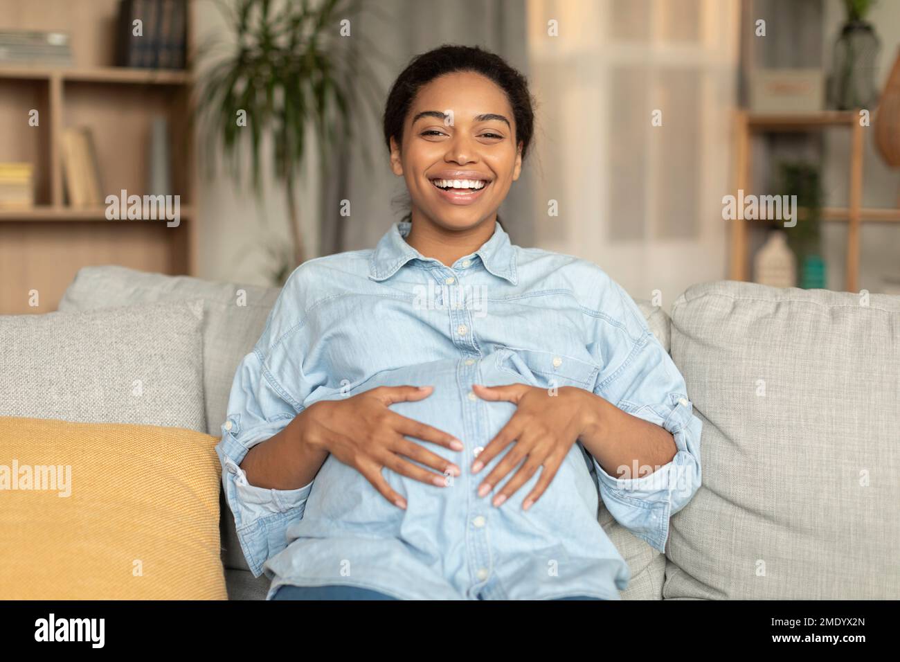 Joy of pregnancy. Happy african american pregnant woman hugging belly ...