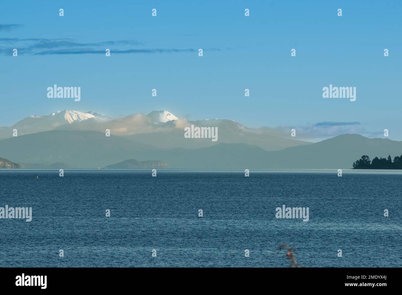 View across Lake Taupo with snow-capped mountains of Tongariro National ...