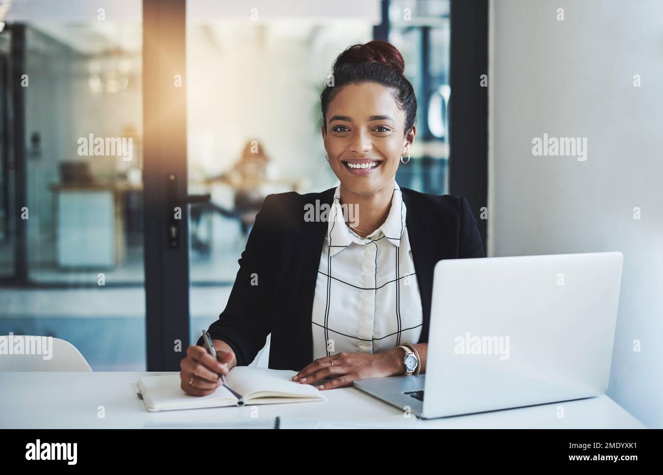 Watch me put my ambition to work. a young businesswoman making notes at ...