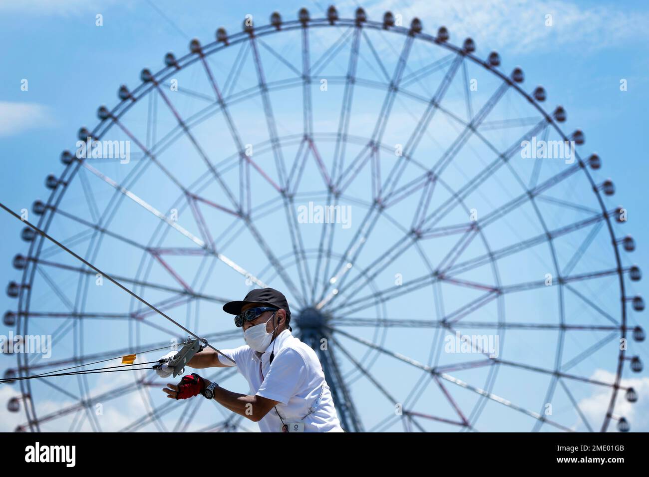 An official wears a mask and gloves as he prepares the cables for the ...