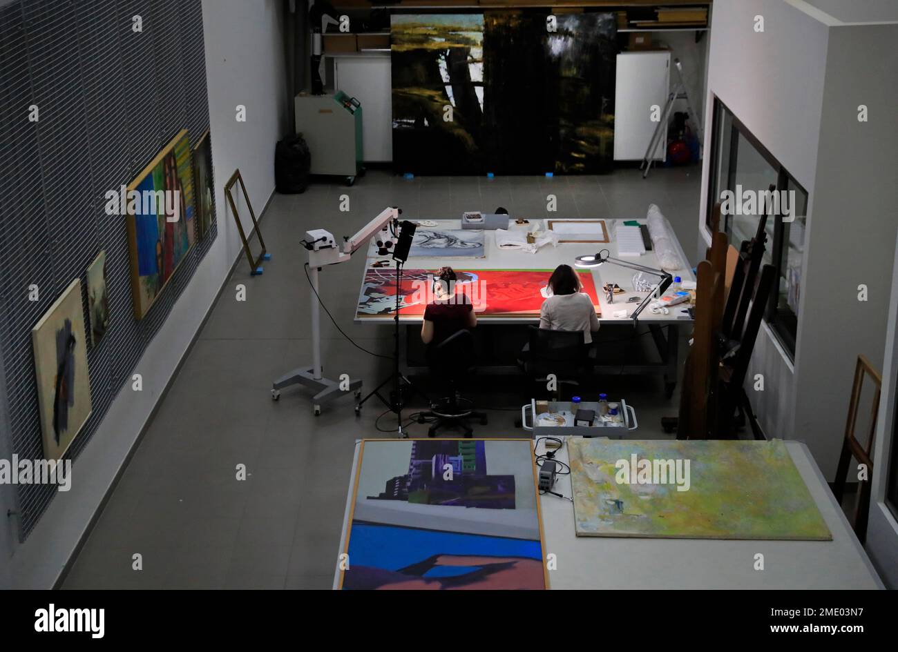 Artists works restoring a painting from the Sursock Museum, that was ...
