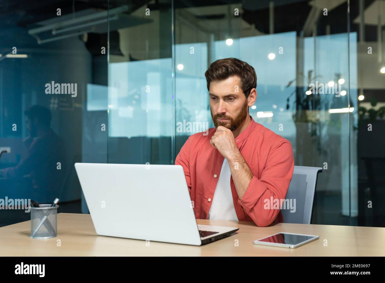 Serious thinking businessman close up, man in red casual shirt working ...