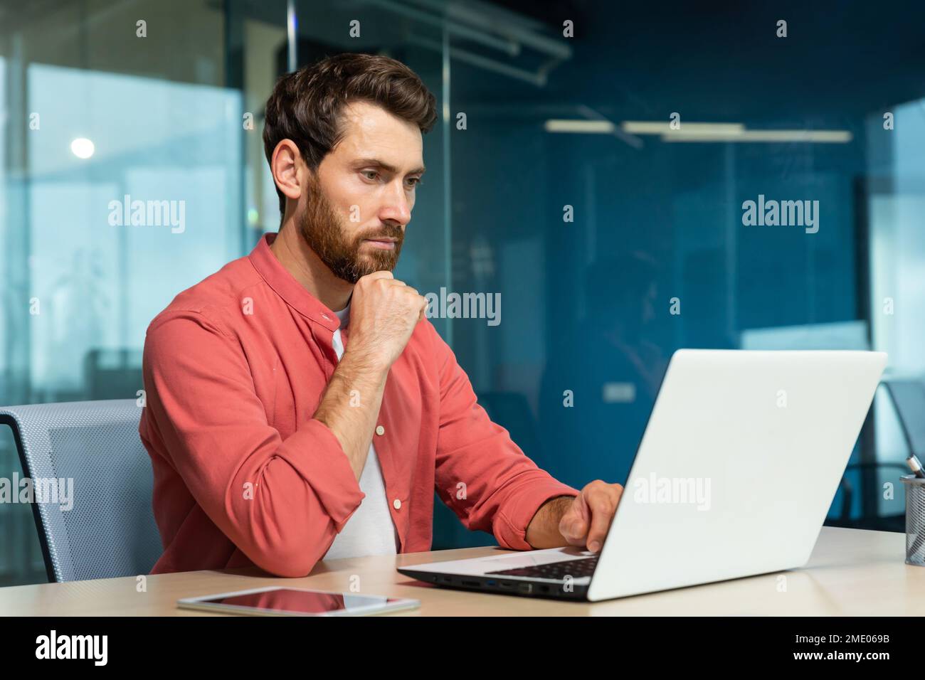 Serious thinking businessman close up, man in red casual shirt working ...