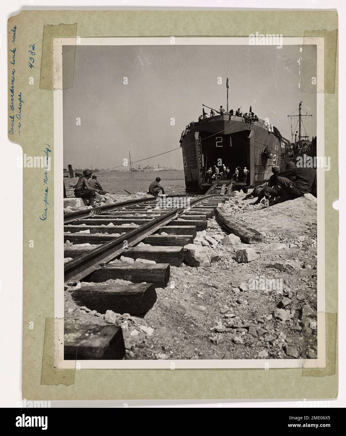 A Coast Guard-manned LST connects with land rails in France to offload ...