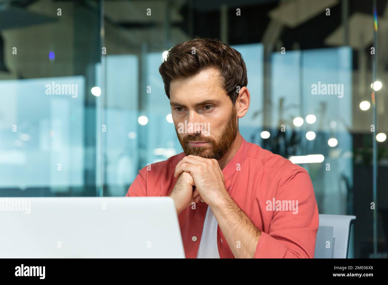 Serious thinking businessman close up, man in red casual shirt working ...