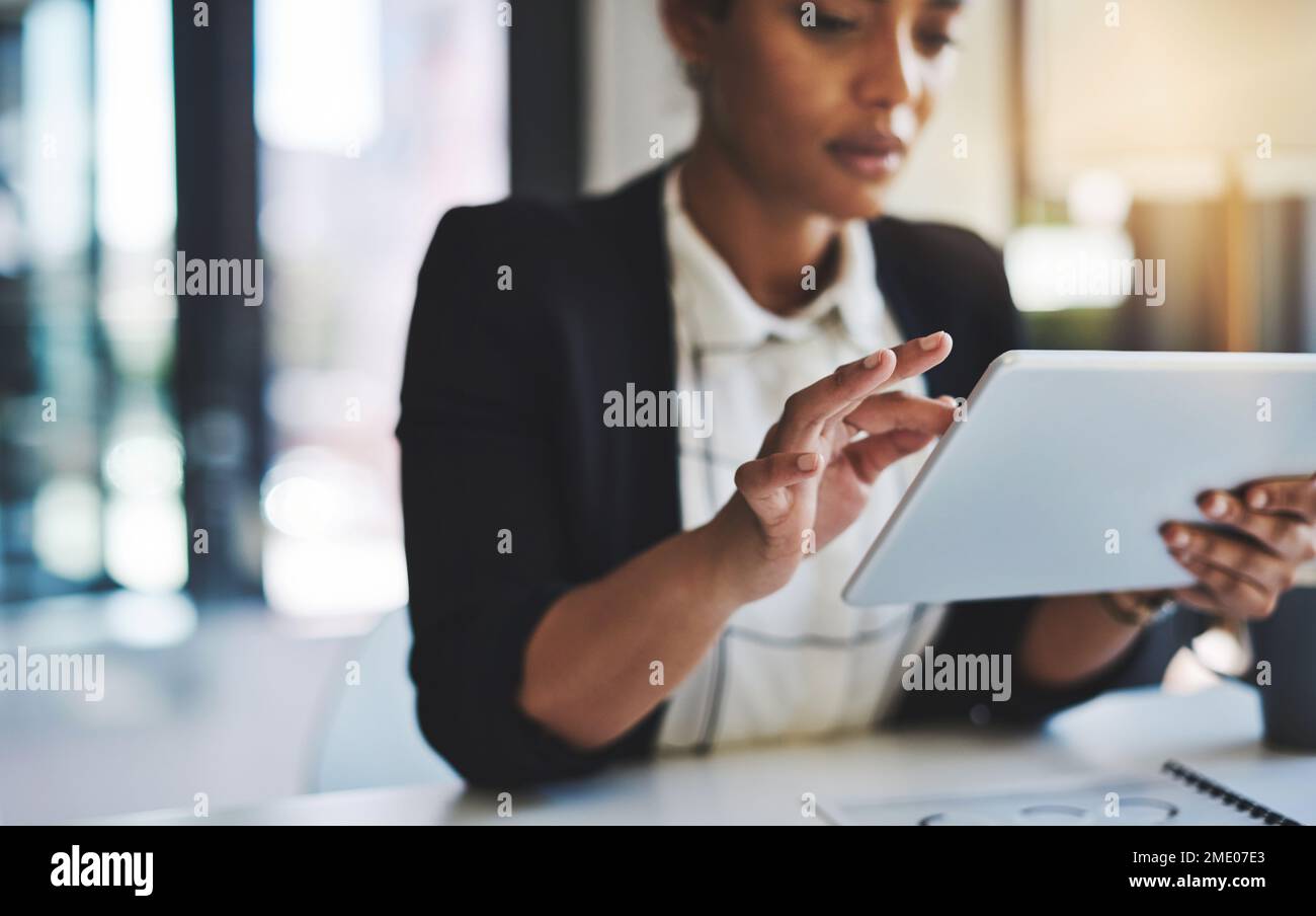 Digitizing her work to do list. a young businesswoman using a digital ...